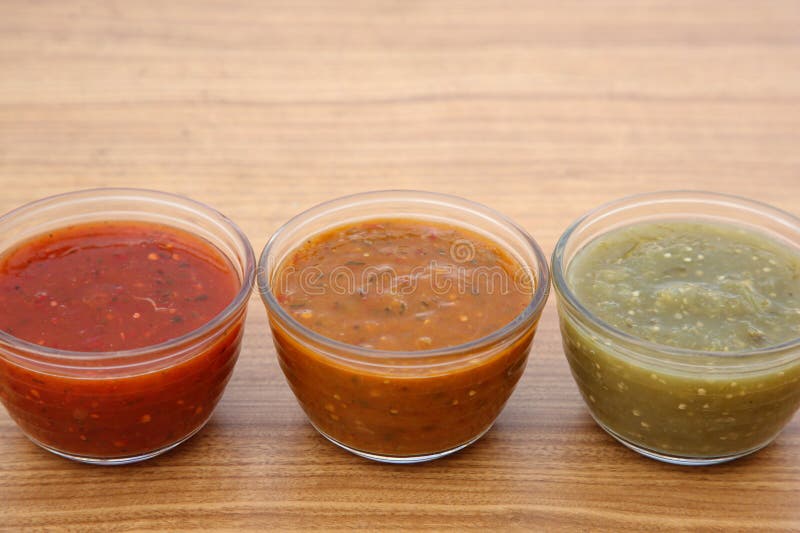 Different Tasty Salsa Sauces on Wooden Table, Closeup Stock Photo ...