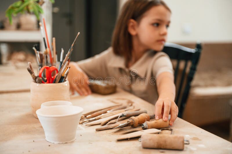 Different Tools on the Table. Little Girl is Learning How To Do Pottery ...