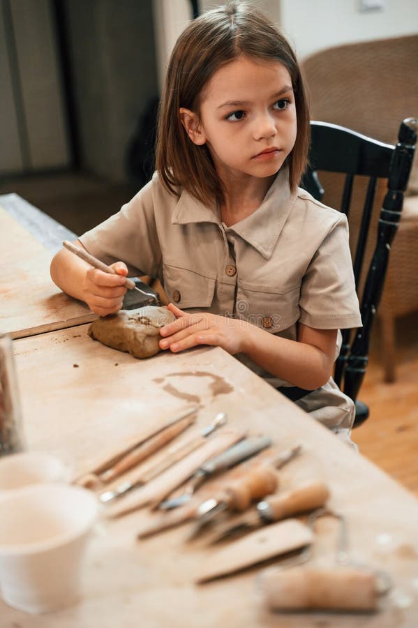 Different Tools on the Table. Little Girl is Learning How To Do Pottery ...