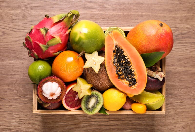 Different Tropical Fruits in Box on Wooden Table, Top View Stock Image ...