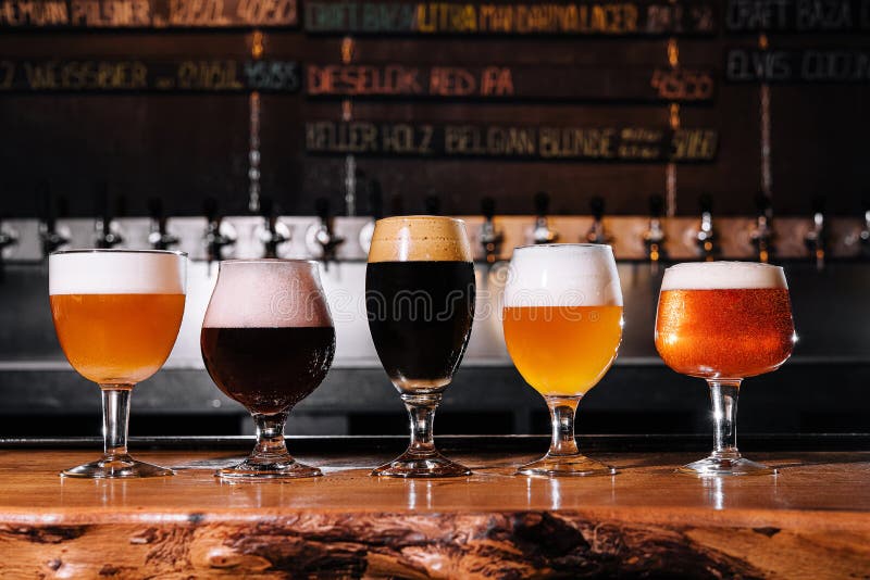 Different Types of Craft Beer in Glasses on Table in Pub Interior Stock ...