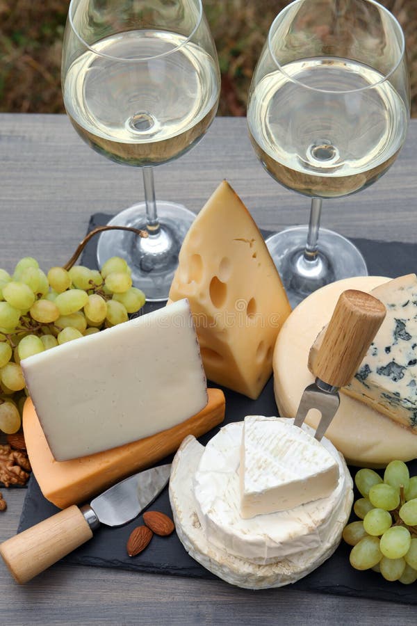 Different Types of Delicious Cheeses, Snacks and Wine on Wooden Table ...