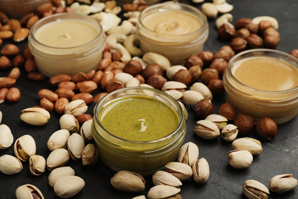 Different Types of Delicious Nut Butters and Ingredients on Black Table ...