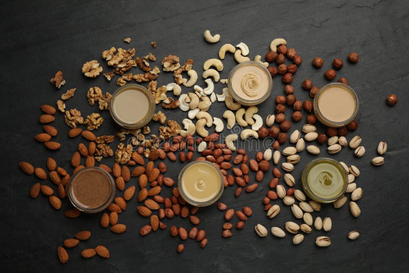 Different Types of Delicious Nut Butters and Ingredients on Black Table ...