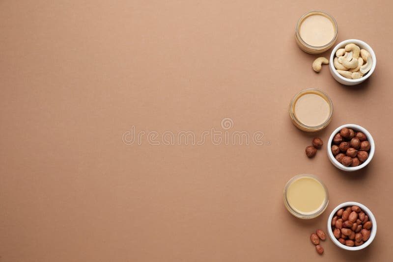 Different Types Of Delicious Nut Butters And Ingredients On Brown Background Flat Lay Space