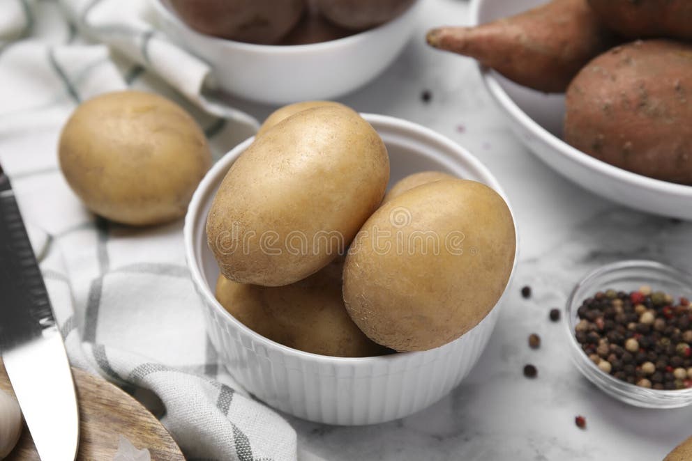 Different Types of Fresh Potatoes in Bowls on White Marble Table ...