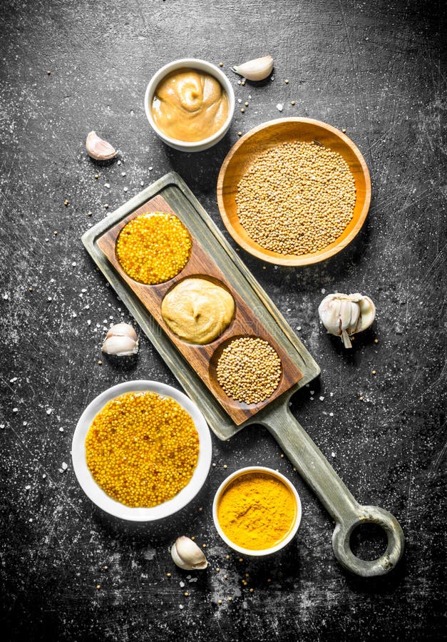 Different Types of Mustard in Plates and on a Stand with Garlic Slices ...