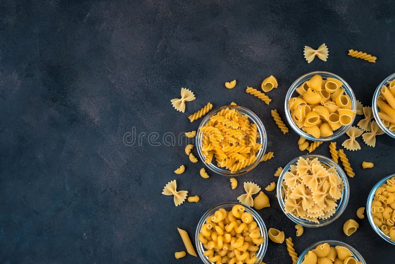 Different Types of Pasta on a Dark Concrete Background. Top View, with ...