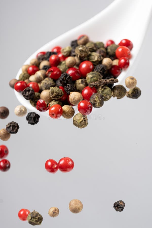 Different Types of Peppercorns Pouring. Red, Green, White and Black ...