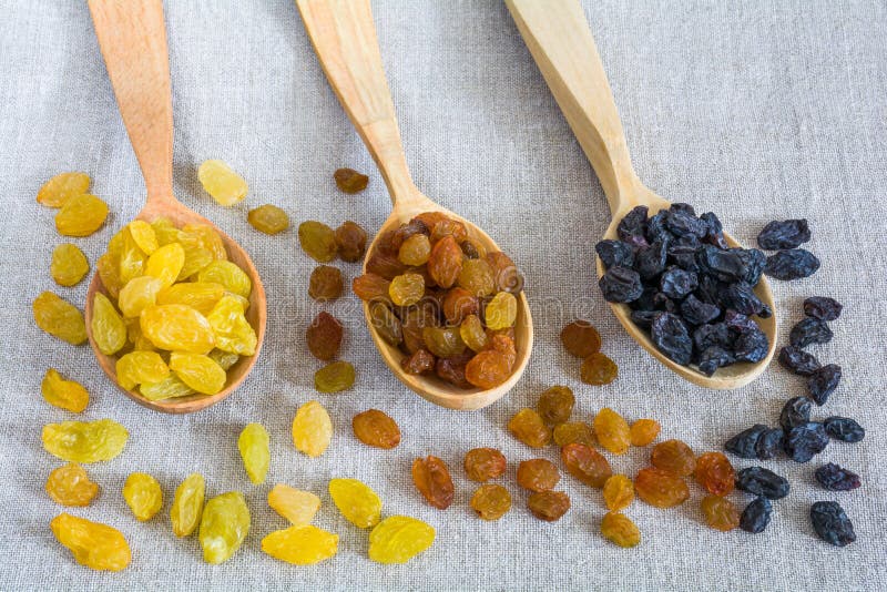 Different Types of Raisins on Wooden Spoons on Sacking Background Stock ...