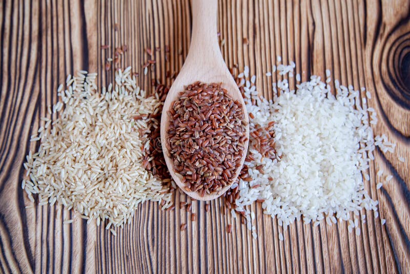 Different Types of Rice on a Wooden Background. White, Brown and Red ...