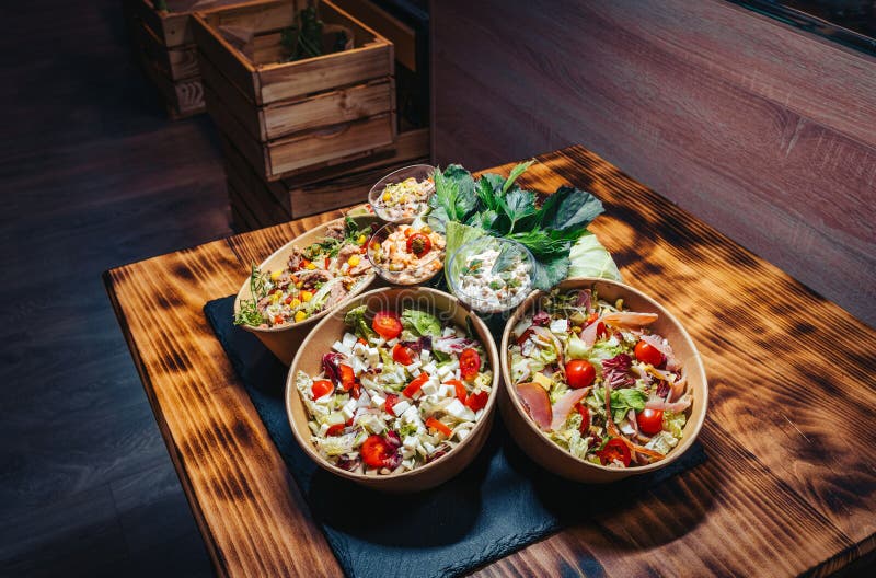 Different Types of Salads in a Bowl on a Wooden Table in a Restaurant ...