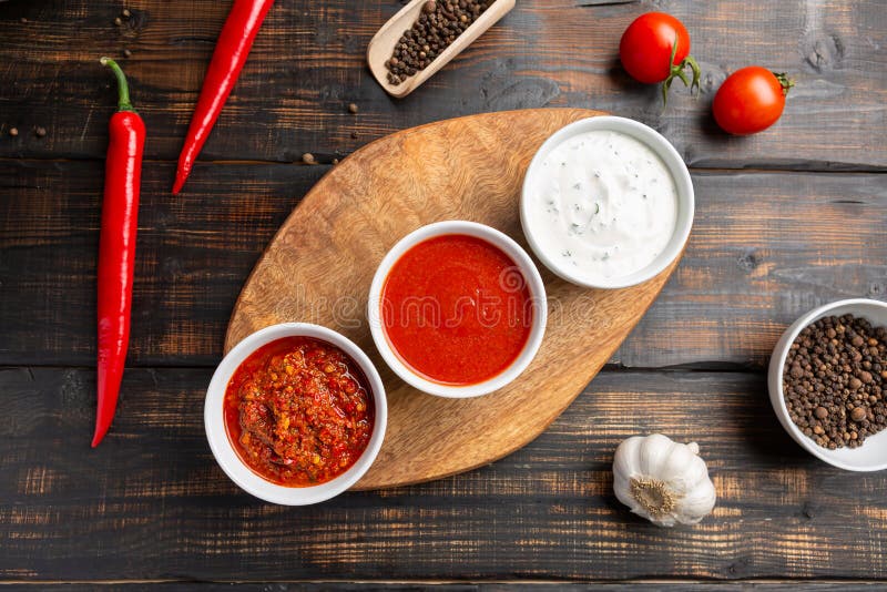 Different Types of Sauces in Bowls on a Cutting Board with Garlic. on ...