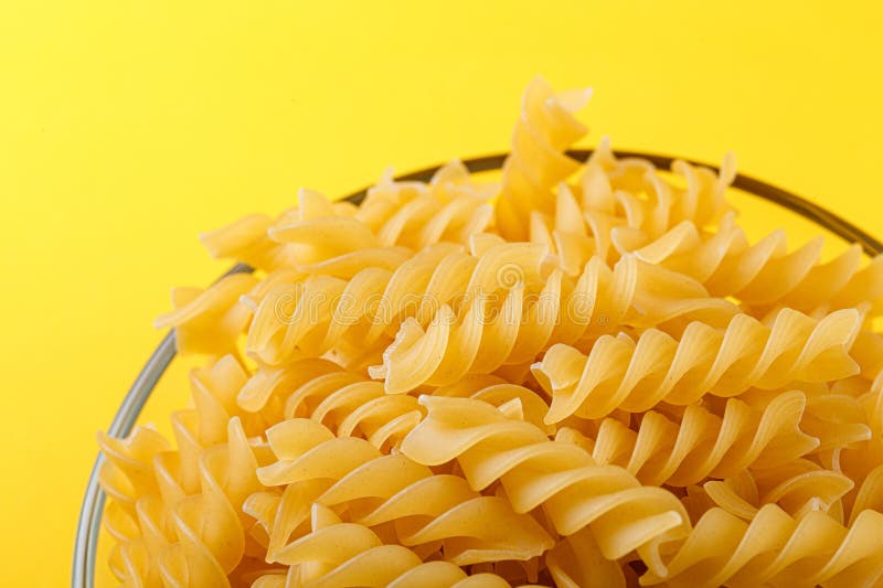 Different Types and Shapes of Dry Italian Pasta on a Yellow Background ...