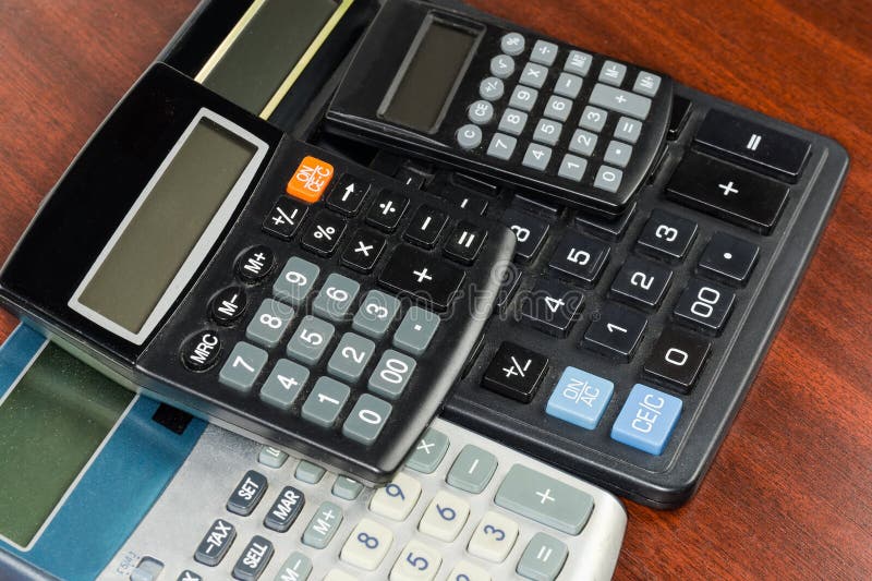 Different Used Electronic Calculators Stacked on Wooden Table ...