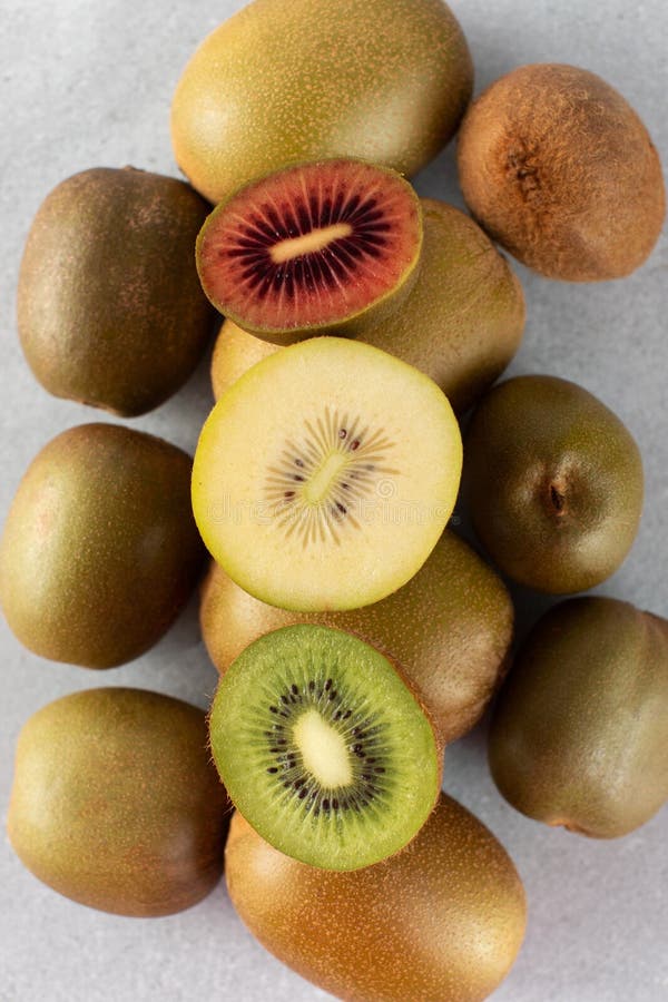 Different Varieties of Kiwi Lie in a Pile on the Table. Halves of Red ... Different Varieties of Kiwi Lie in a Pile on the Table. Halves of Red ...