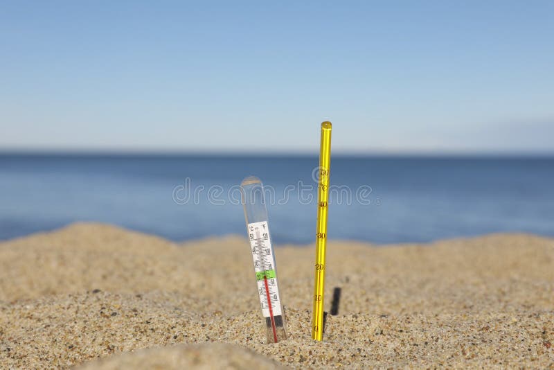 Different Weather Thermometers in Sand Near Sea Stock Photo - Image of ...