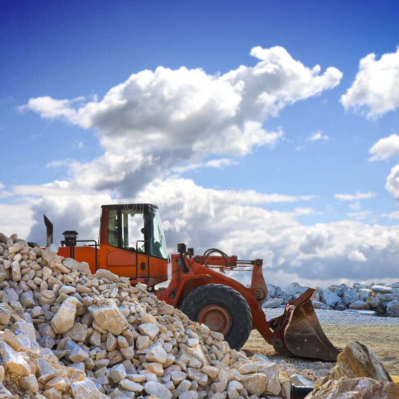A Digger Builds a Dam of White Stones on a Construction Site Stock ...