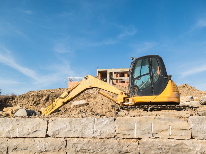 Digger on a Construction Site Building a Stone Wall Stock Image - Image ...