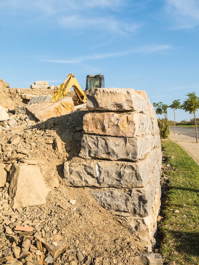 Digger on a Construction Site Building a Stone Wall Stock Photo - Image ...