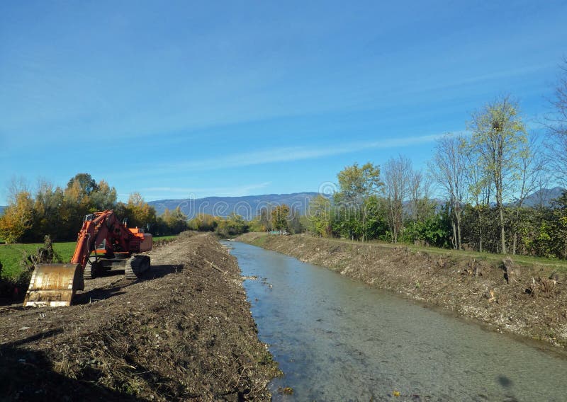 Digger on the River Bank during Maintenance Work on the Embankment ...