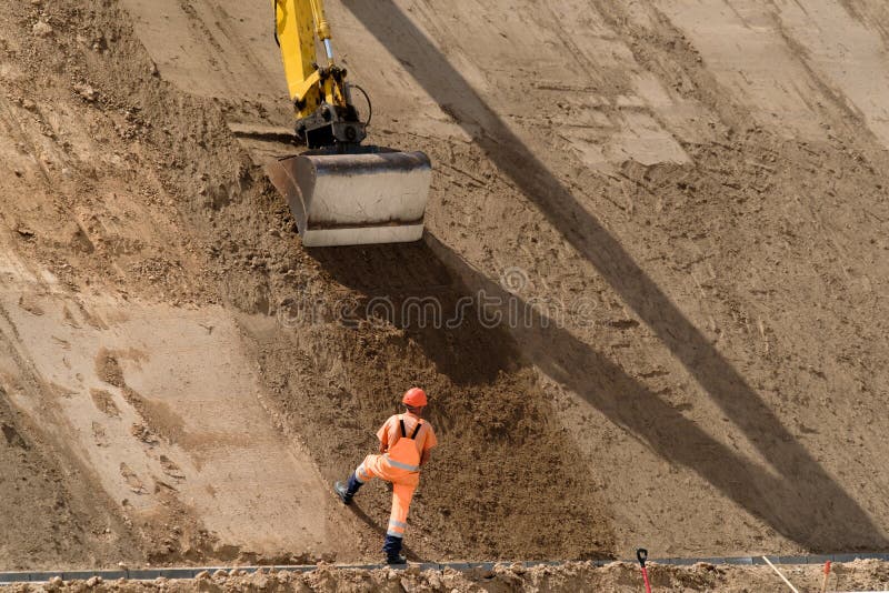 Works On A Road Construction Site With The Digger And The Worker Stock ...