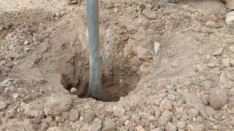 Digging a Hole in the Ground Using a Crowbar Stock Video - Video of ...