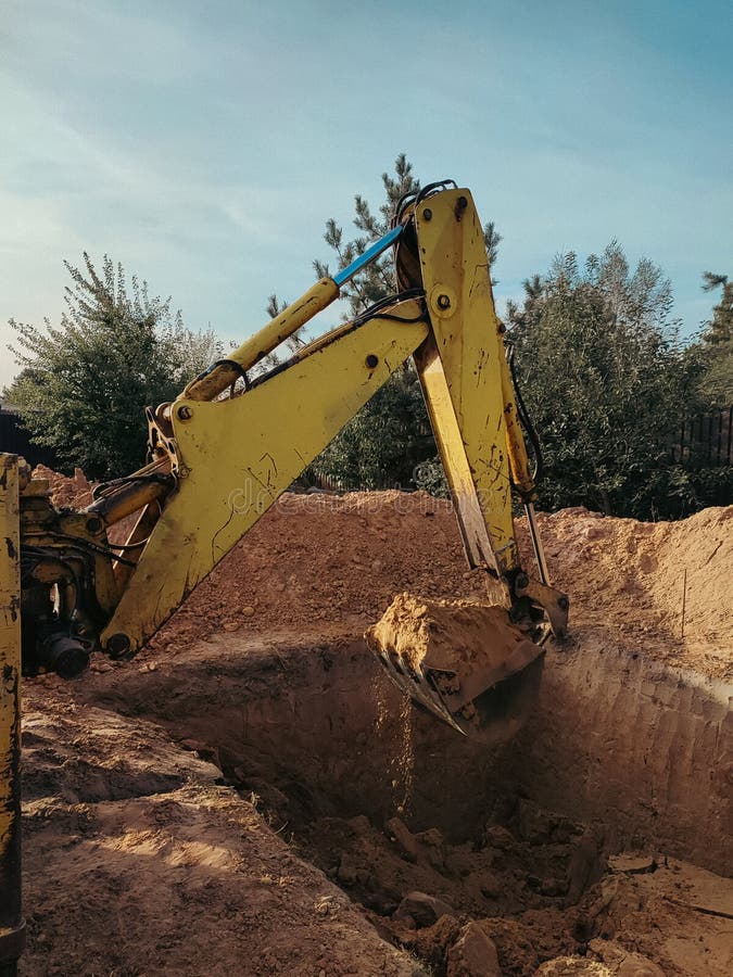 Digging the Pit Foundation a Hole with Excavator at the Construction ...