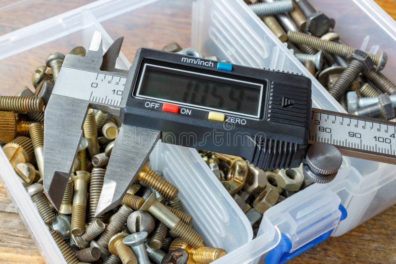 Digital Electronic Caliper on Storage Box with Bolts and Nuts on Wooden ...