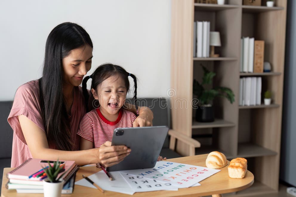 Digital Learning and Fun. a Mother and Daughter Discover Educational Content on a Tablet ...