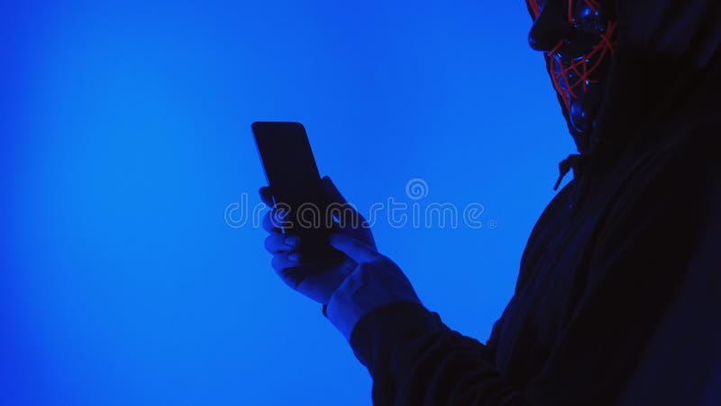 Digital Security Concept. Anonymous Hacker with Mask Holding Smartphone ...
