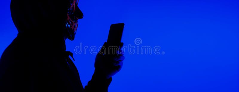 Digital Security Concept. Anonymous Hacker with Mask Holding Smartphone ...