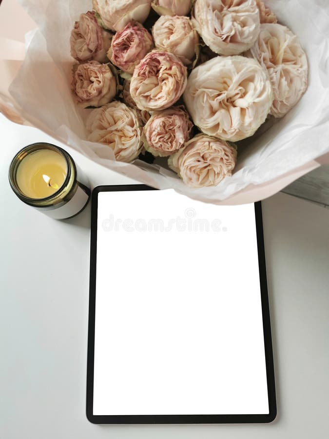 Digital Tablet with a Blank Screen on a Table with a Bouquet of Spray ...