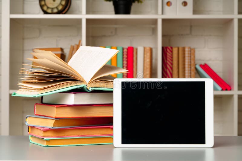 Digital Tablet with Stacked Books in Library Stock Photo - Image of ...