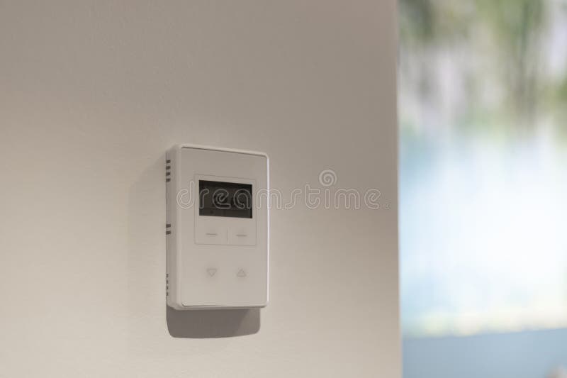 A Digital Thermostat is Mounted on a Wall Displaying a Temperature of ...