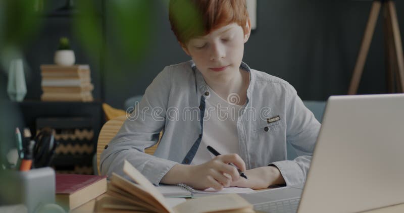 Diligent Child Doing Homework Reading Book and Using Laptop in ...