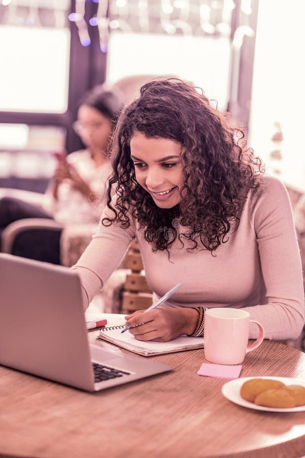 Diligent Curly Student Making Some Notes while Watching Education Video ...