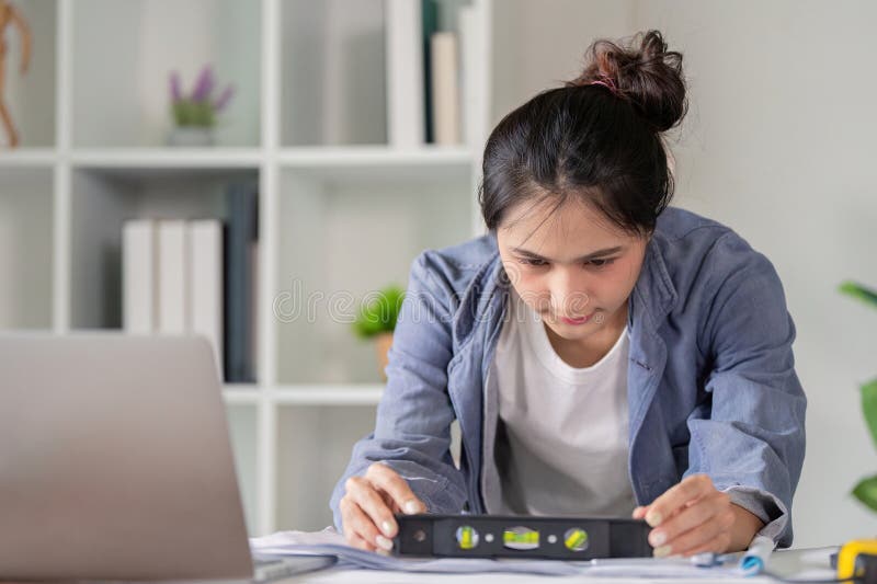Diligent Female Engineer Using Level Tool To Review Project Details in ...
