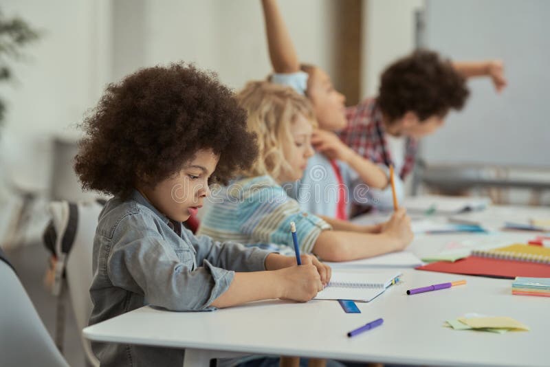 Diligent Little Girl Sitting Behing a Big Table, Drawing in Front of a ...