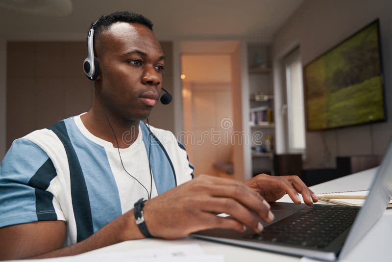 Diligent Man Working on Laptop with Headset on Stock Image - Image of ...