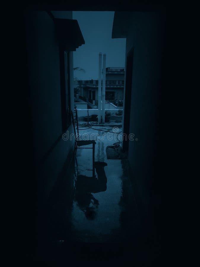 Dimly Lit Hallway with a Wet Floor, Featuring a Single Chair in the ...