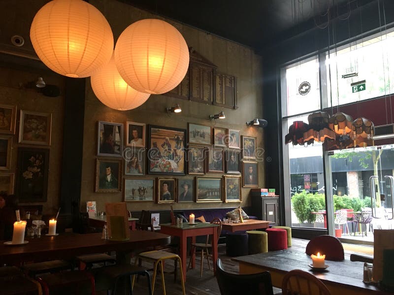 The Dimly Lit Restaurant Space, Decorated with Artwork, is Very ...