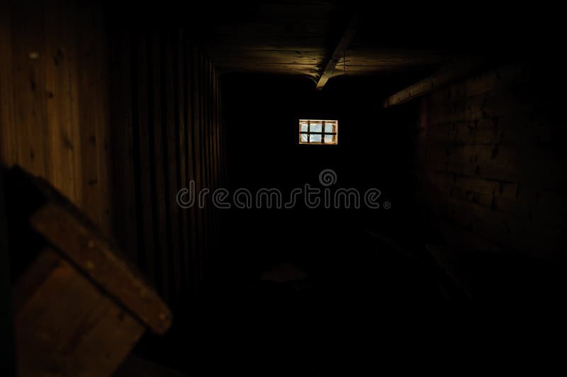 A Dimly Lit, Rustic Wooden Interior with a Small Square Window Emitting ...