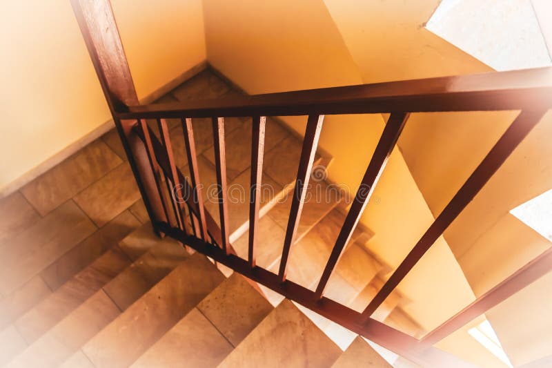 A Dimly Lit Staircase with Metal Railing and Tile Steps and Light ...