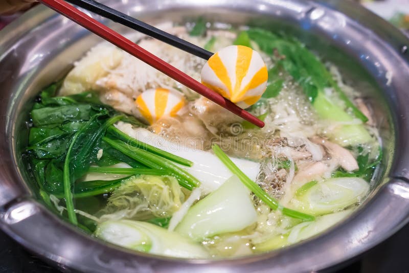 Diners Enjoying a Hot Pot Filled with Vegetables and Meatballs Stock ...