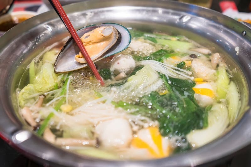 Diners Enjoying a Hot Pot Filled with Vegetables and Meatballs Stock ...