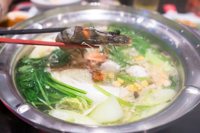 Diners Enjoying a Hot Pot Filled with Vegetables and Meatballs Stock ...