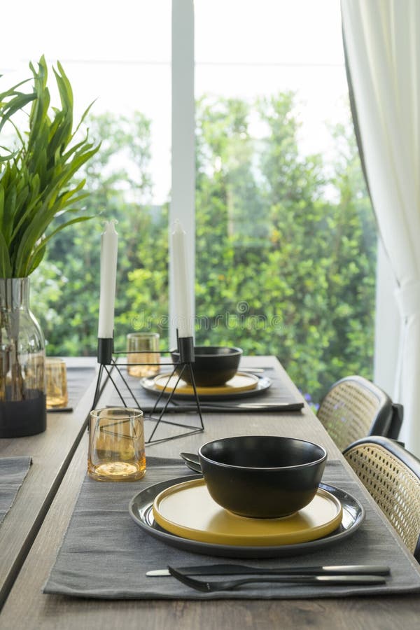 Dining Table with Black and Yellow Plate Setting in Home. Stock Photo ...