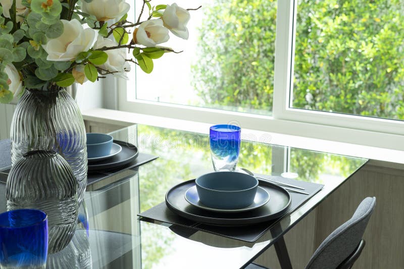 Dining Table with Grey and Blue Plate Setting in Modern Home. Editorial ...