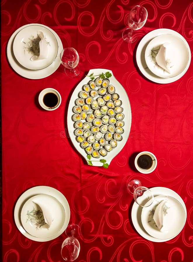 Dining Table with Red Tablecloth and Trays of Sushi and Soya Sauce ...